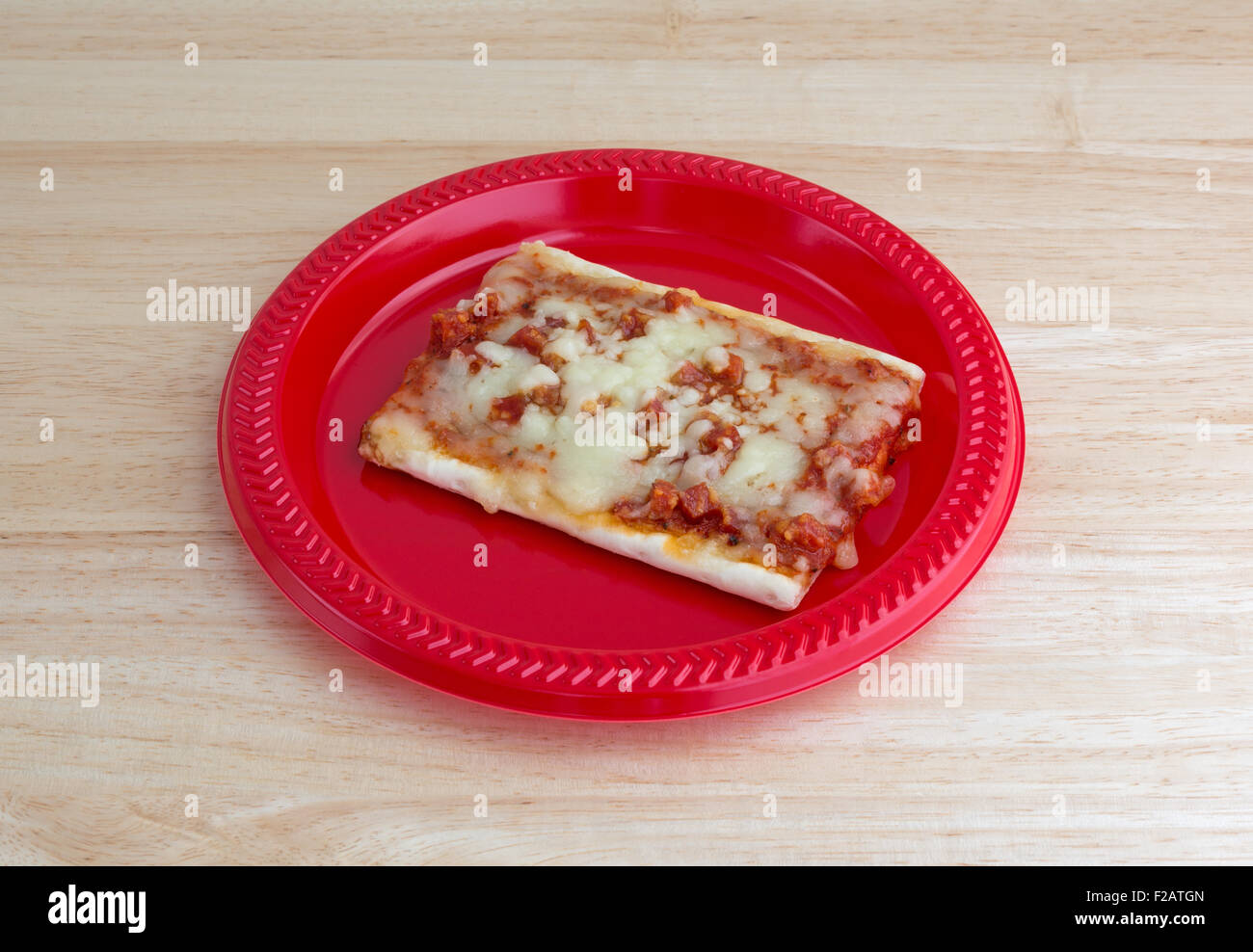 A rectangular slice of chopped pepperoni and mozzarella cheese pizza on ...