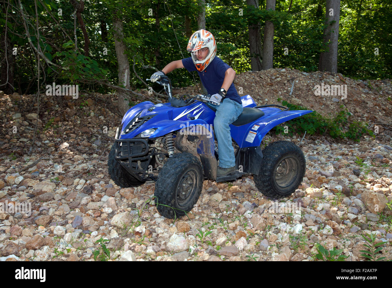 A boy riding on a blue ATV Stock Photo - Alamy