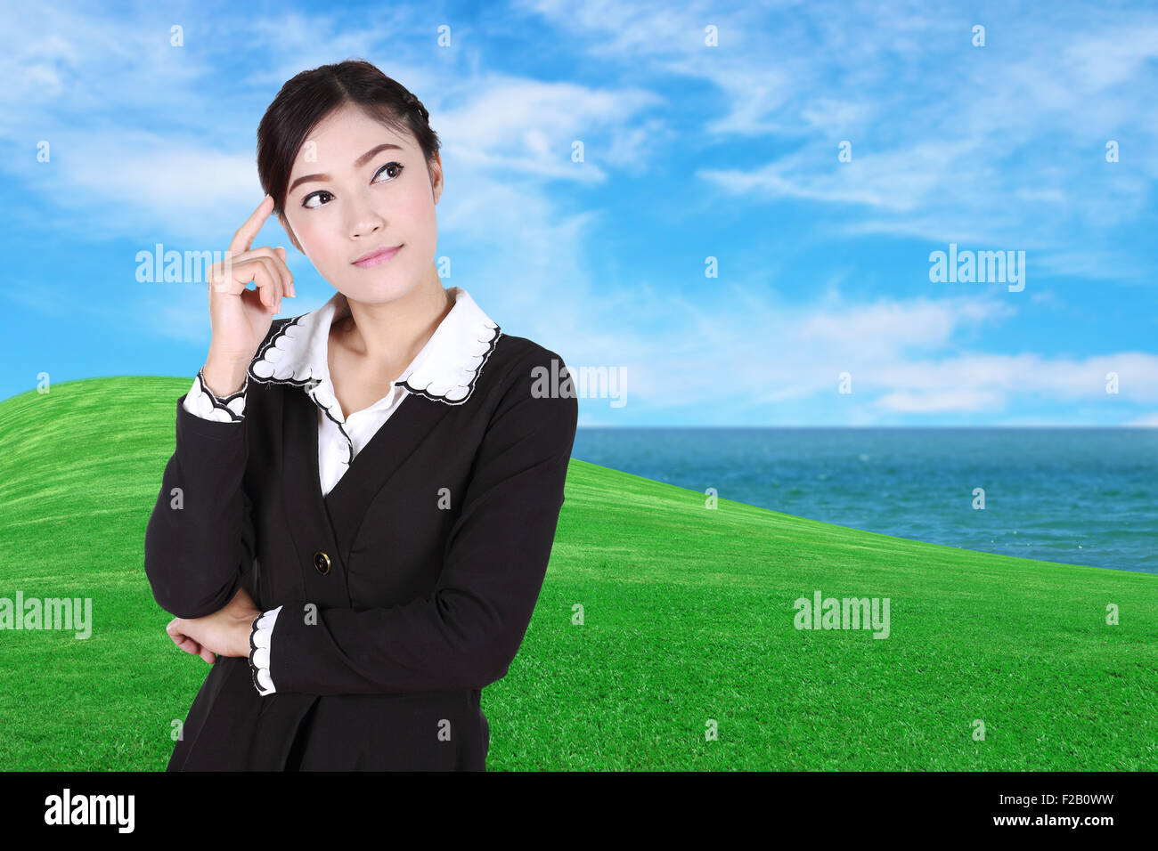 Business woman thinking with green grass field and sea background Stock ...