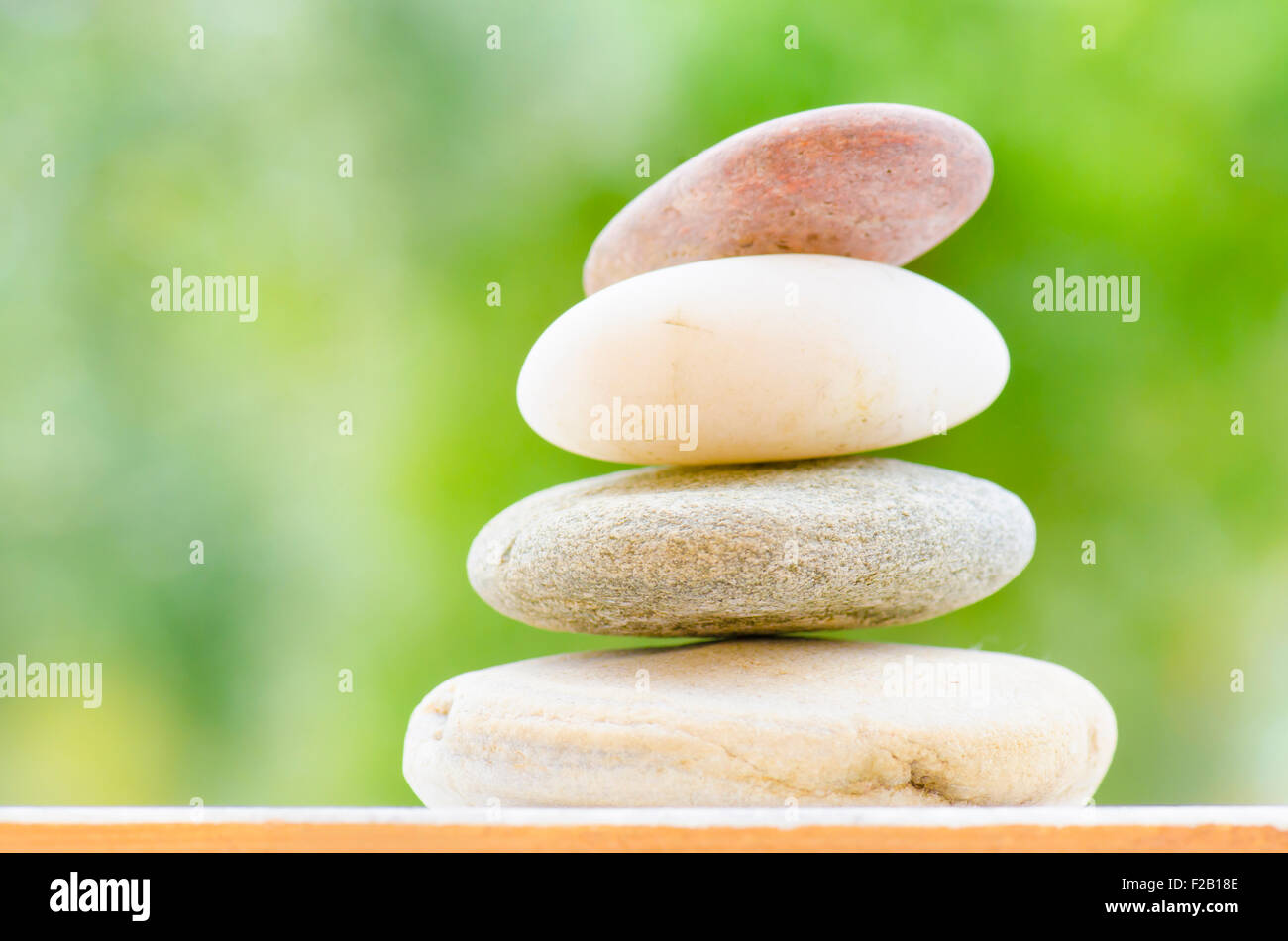 3 rocks pyramid of different colors on wood green background Stock ...