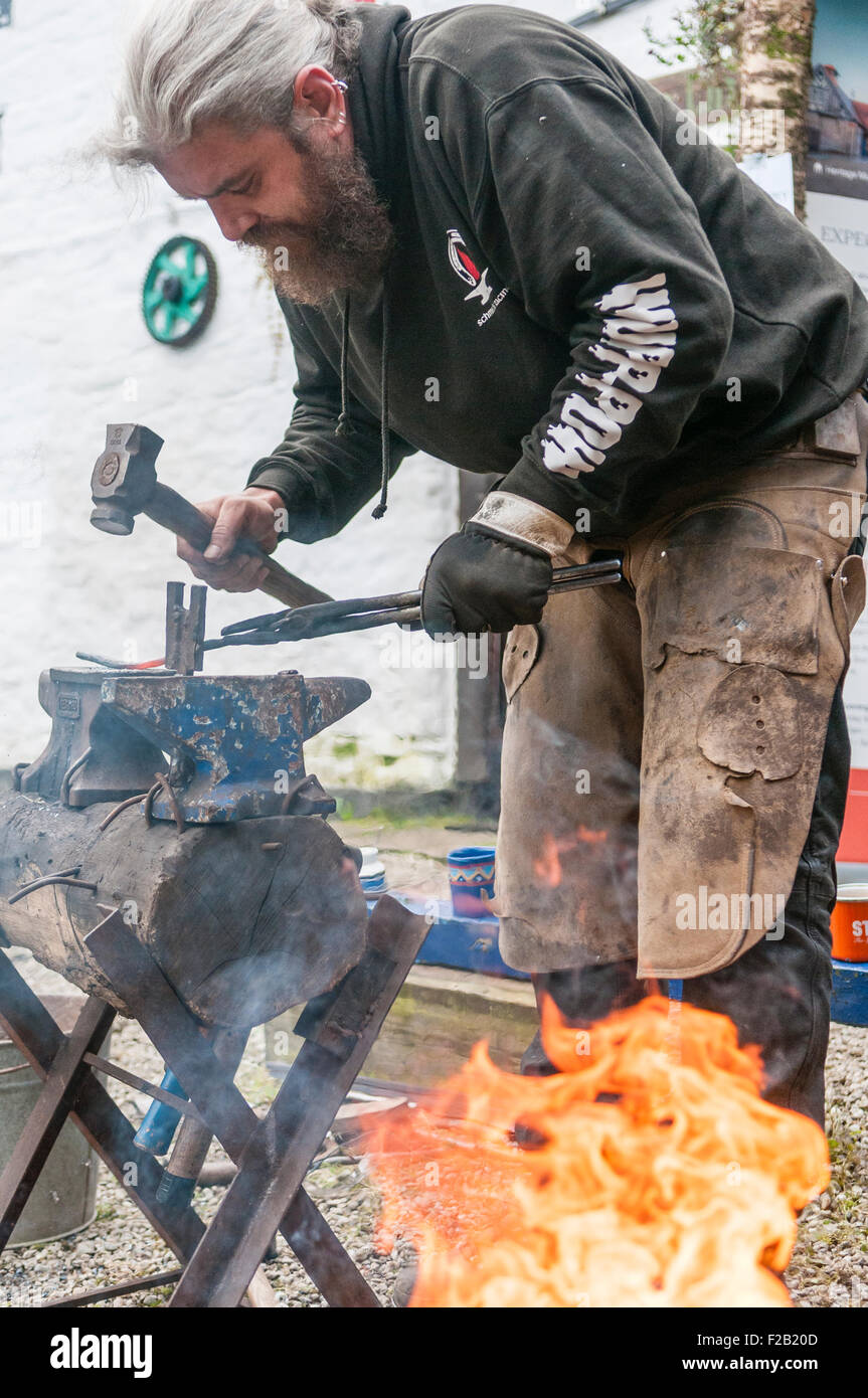 A blacksmith hammers a piece of wrought iron on an anvil Stock Photo ...