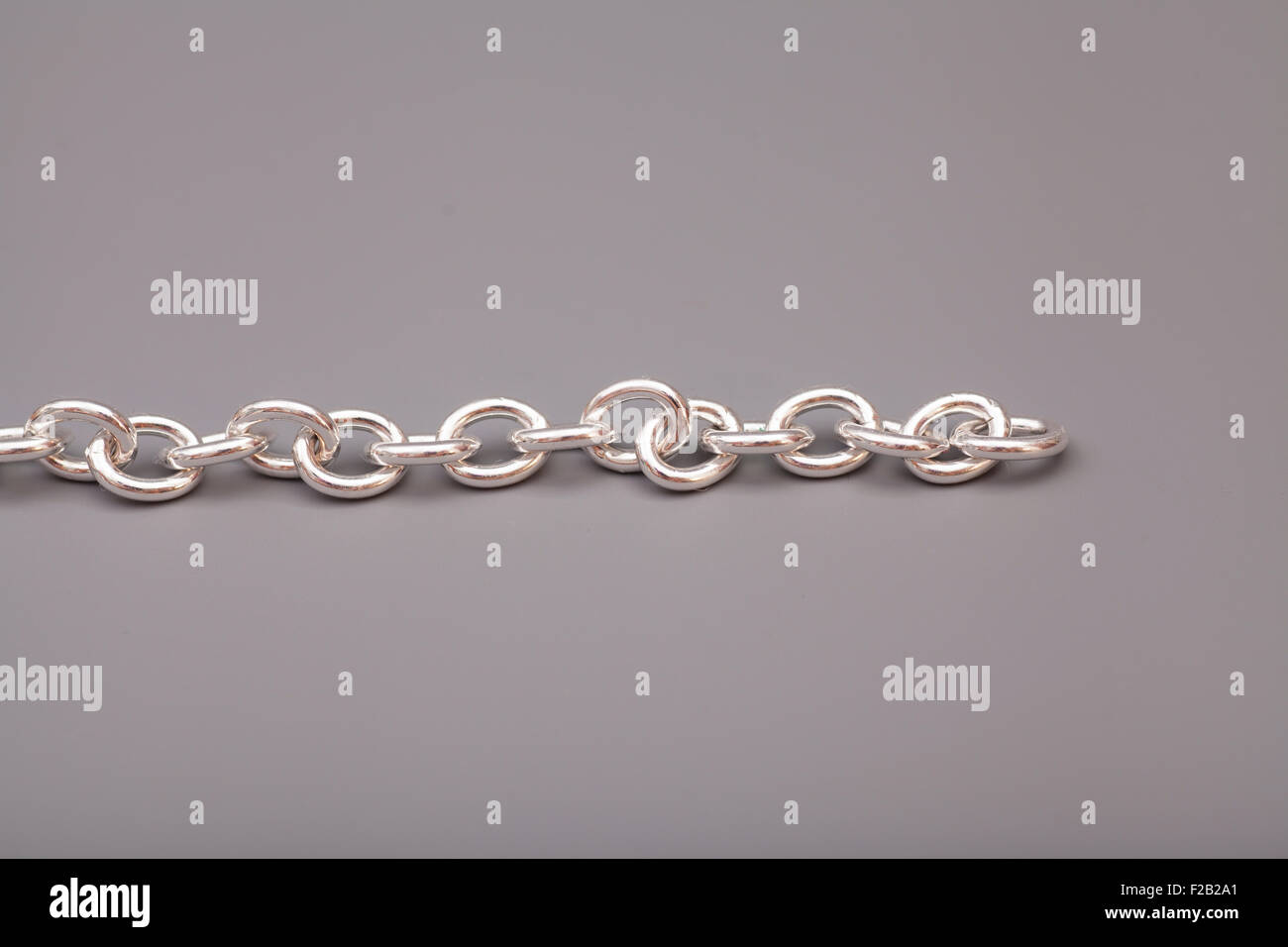 Silver chain on gray background Stock Photo - Alamy