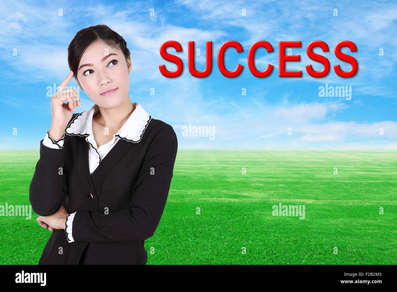 business woman thinking about "success" with green grass field and blue ...