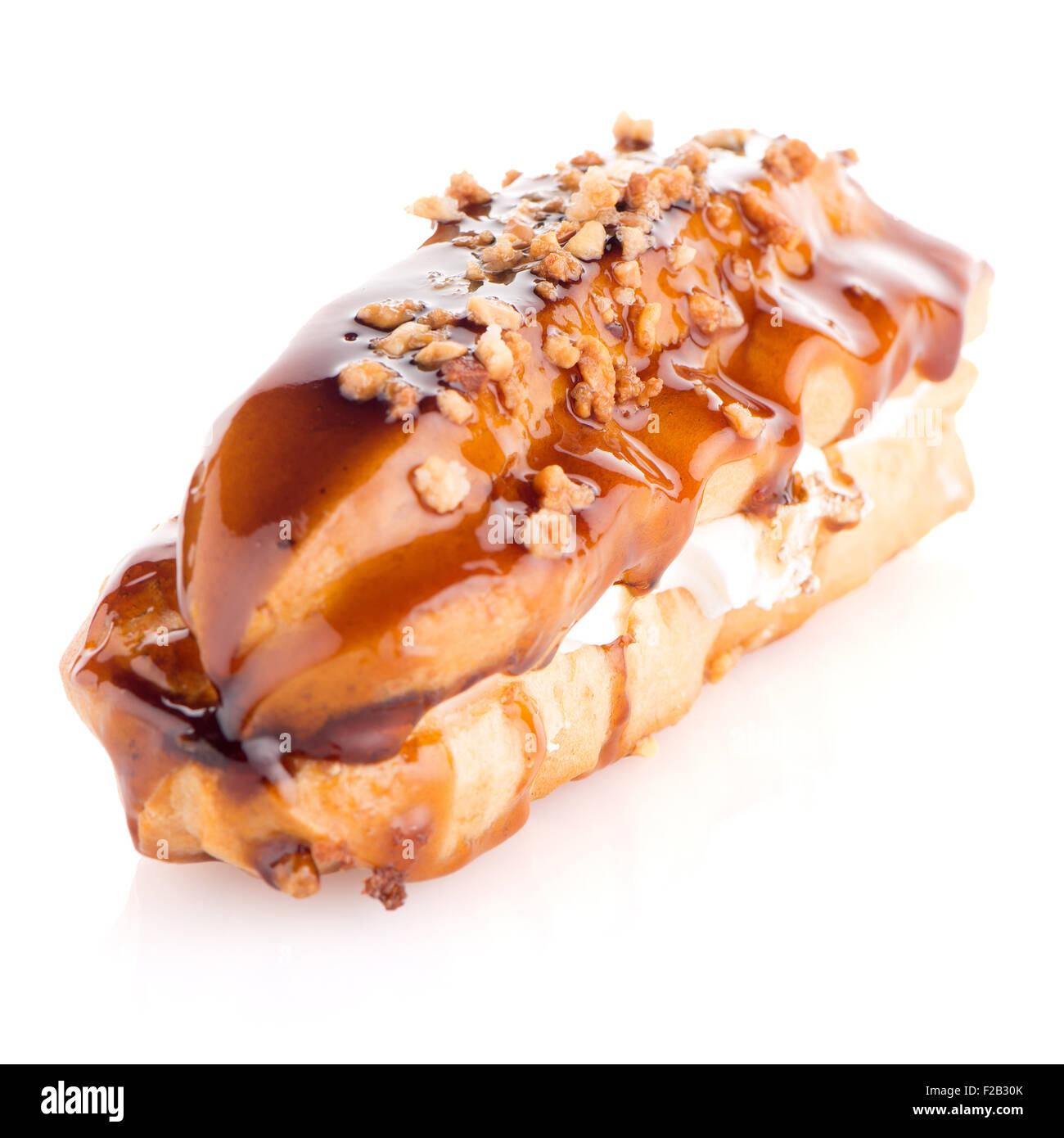 Eclair with caramel decoration on white reflective background Stock ...