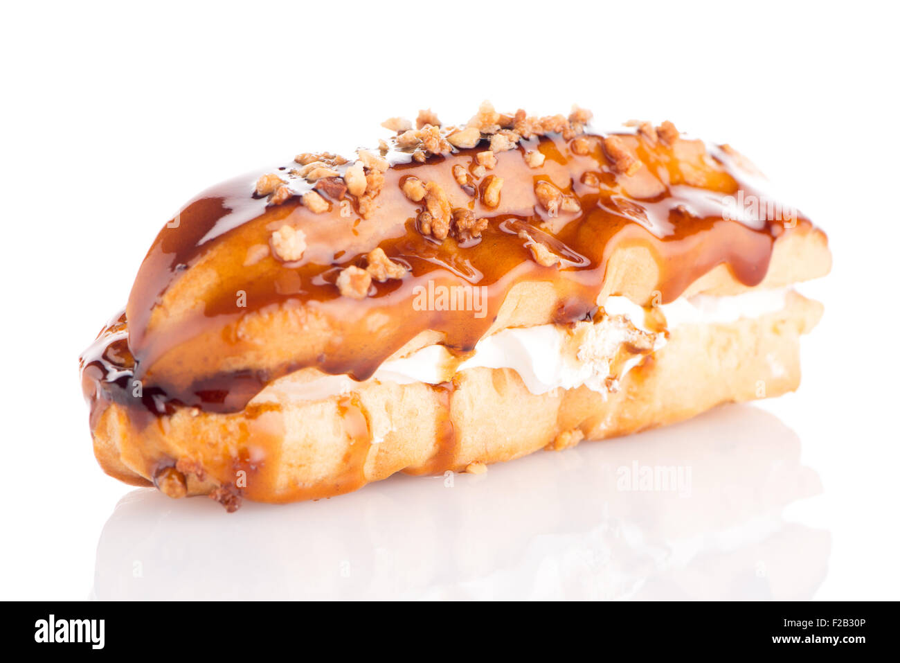 Eclair with caramel decoration on white reflective background Stock ...