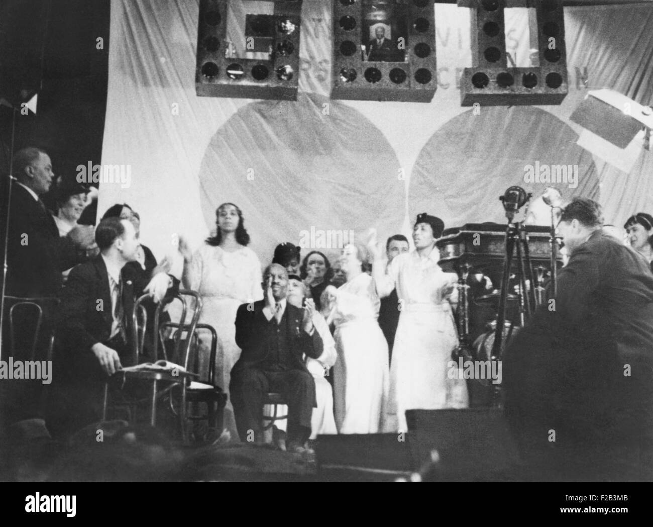 Father Divine leading the singing at one of his meetings. On stage with ...