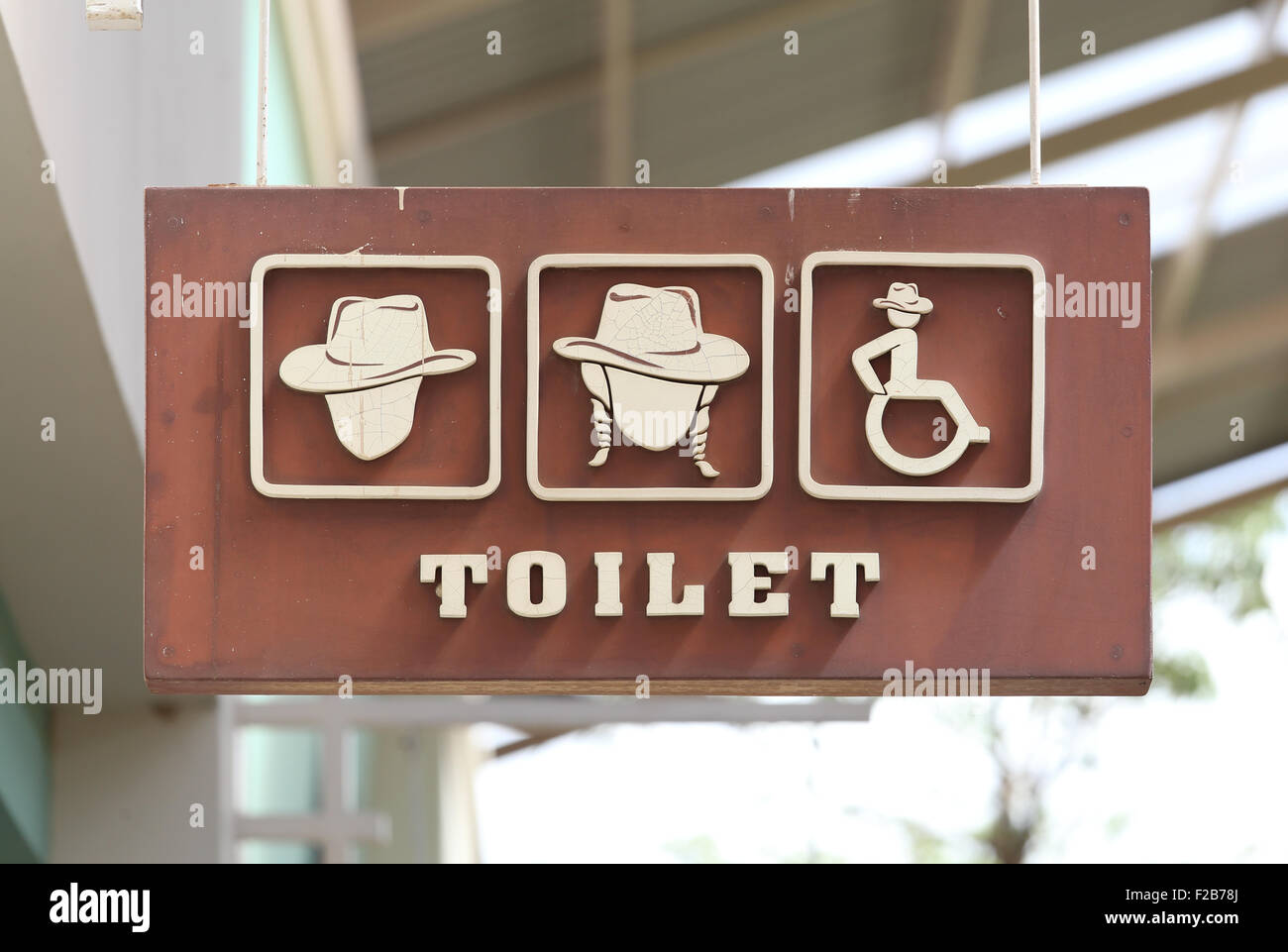 toilet sign hanging on wall with roof background Stock Photo - Alamy
