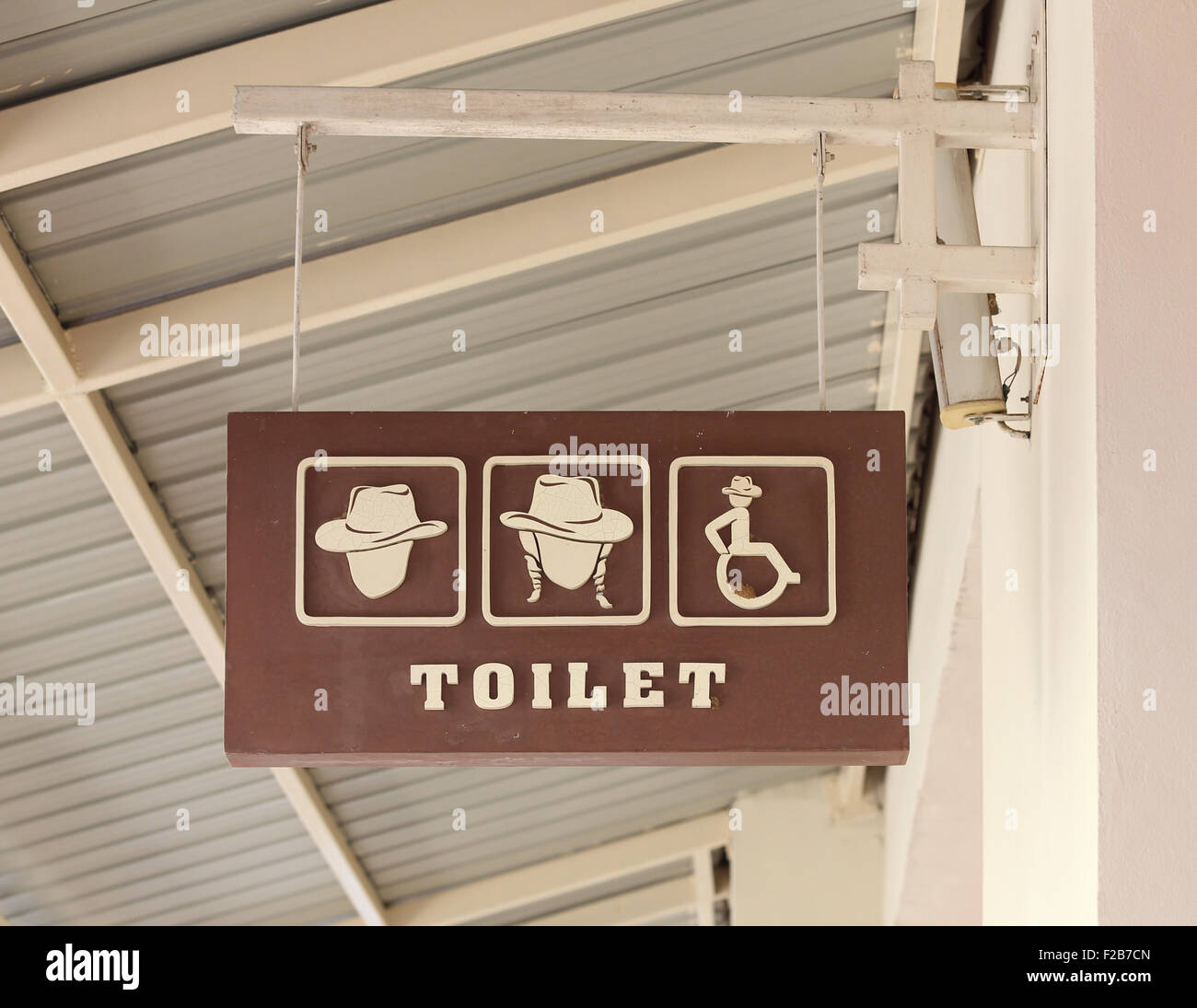 toilet sign hanging on wall with roof background Stock Photo - Alamy