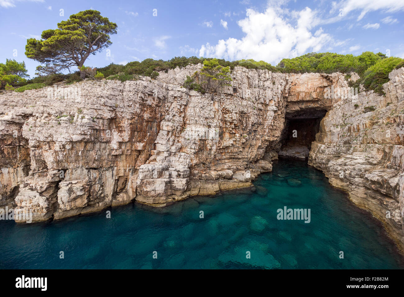 Empty sea cave, shallow water and steep and rugged cliff at the Lokrum ...