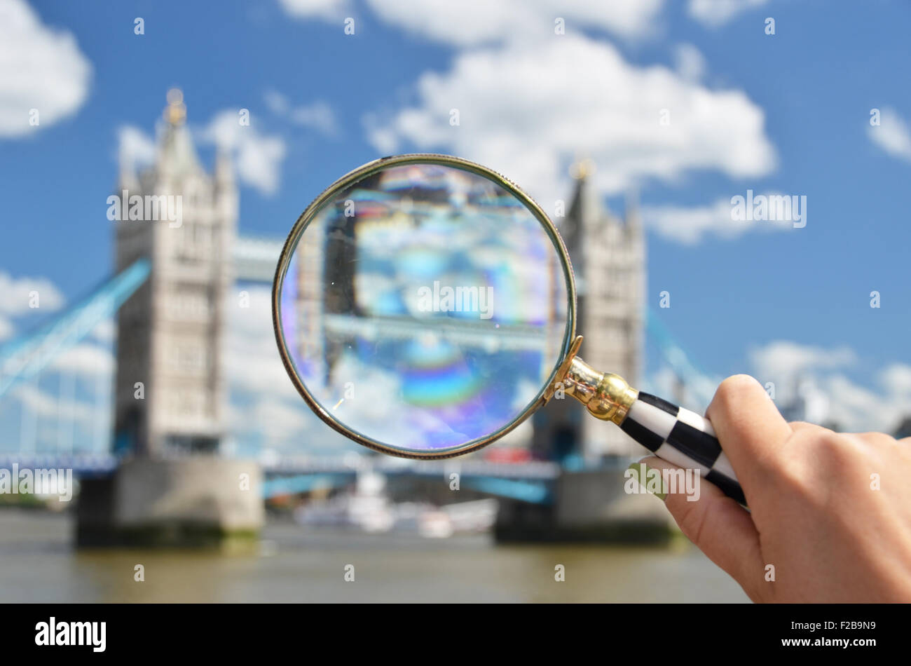 Magnifying glass in the hand against Tower bridge in London Stock Photo ...