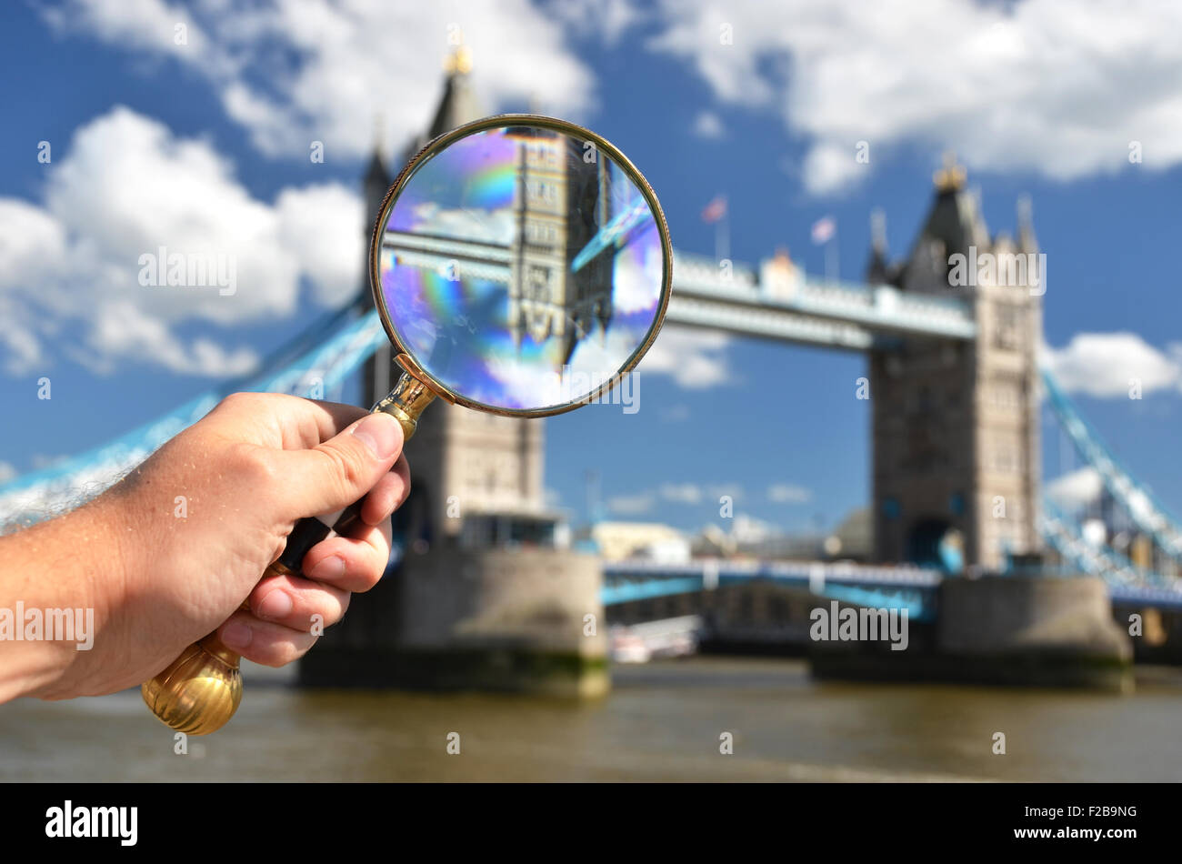 Magnifying glass in the hand against Tower bridge in London Stock Photo ...