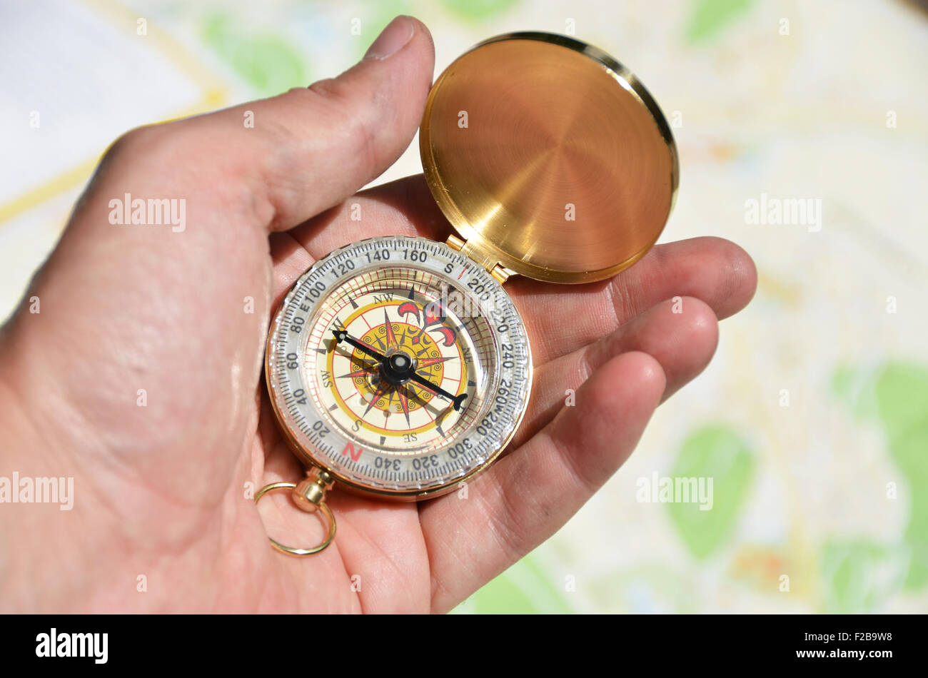 Compass in the hand against map Stock Photo - Alamy