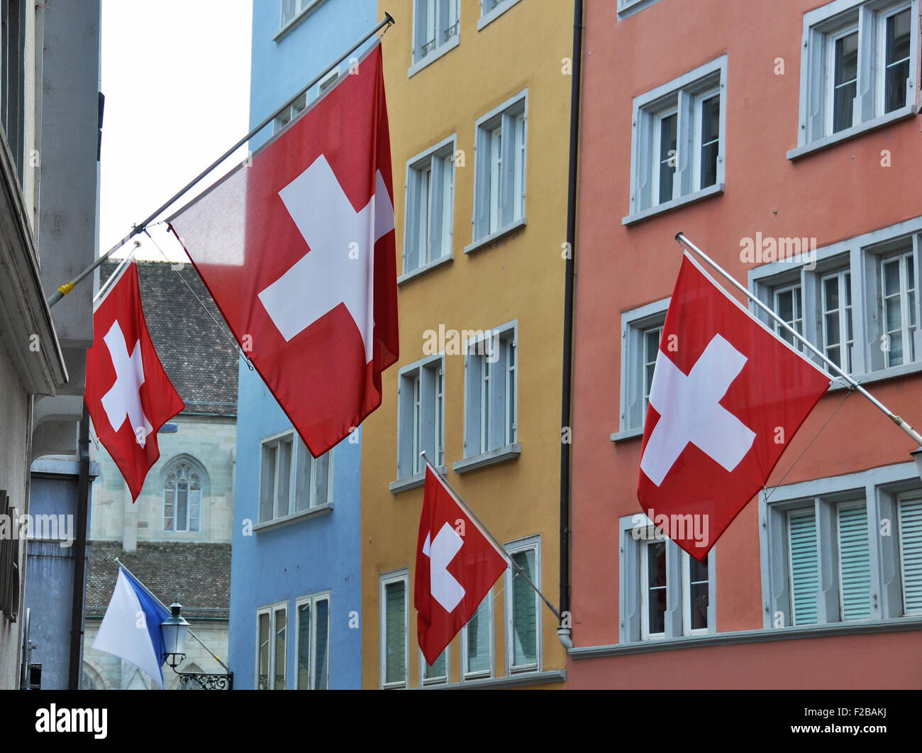 Old street in Zurich decorated with flags for the Swiss National Day ...