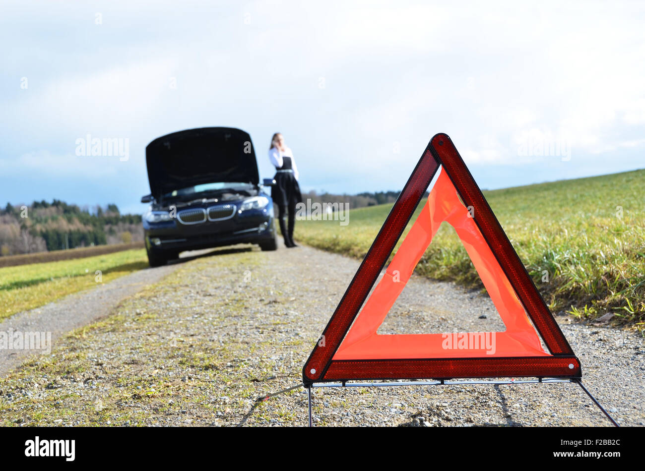 Girl, broken car and triangle Stock Photo - Alamy