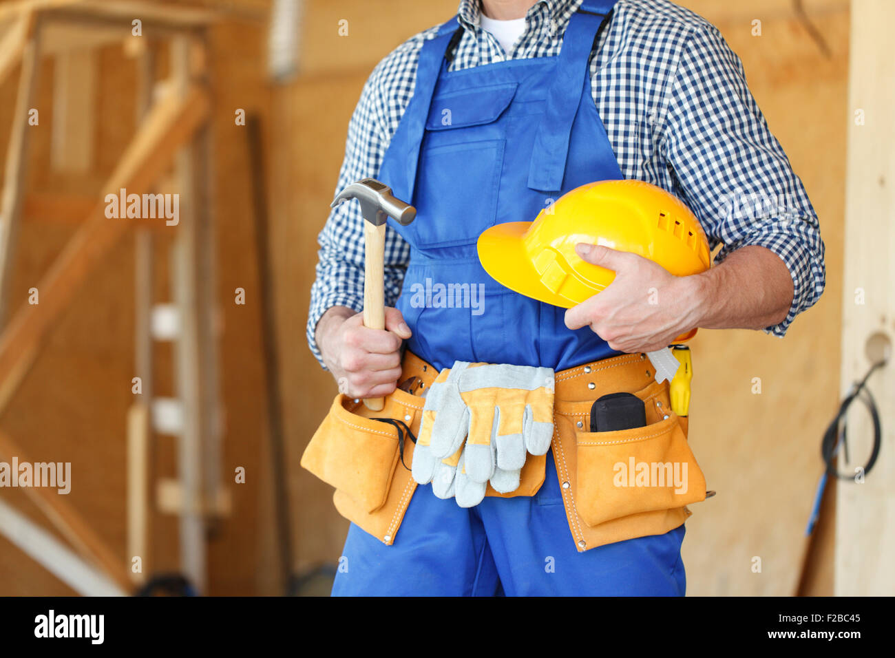 Construction worker with helmet and hammer in new wooden house Stock ...