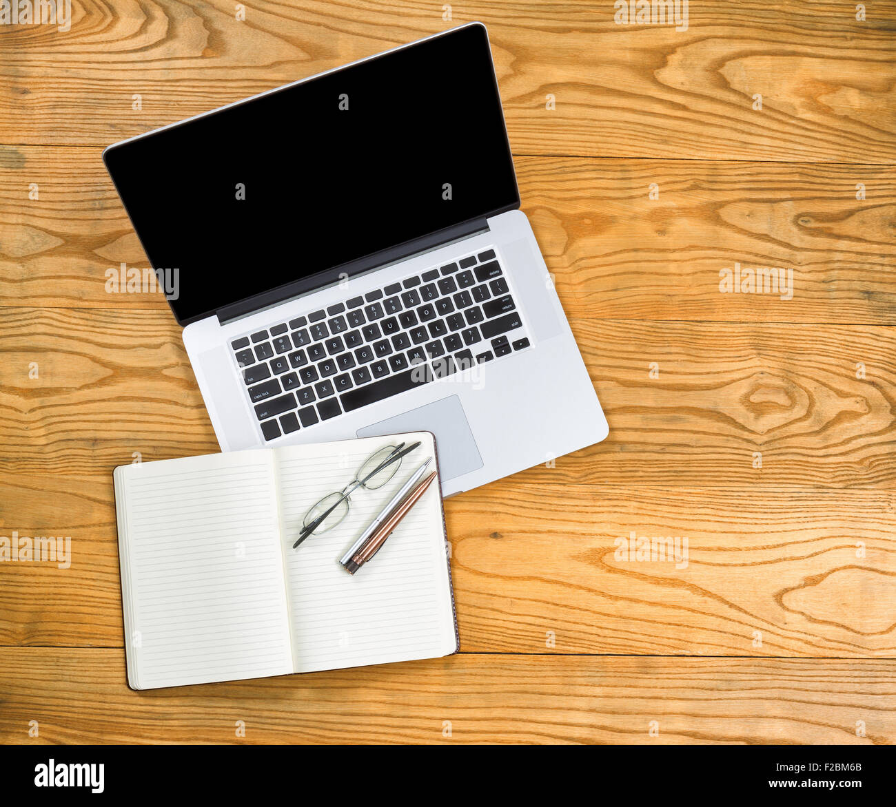 Top view of laptop computer laptop with open notebook and pens on ...