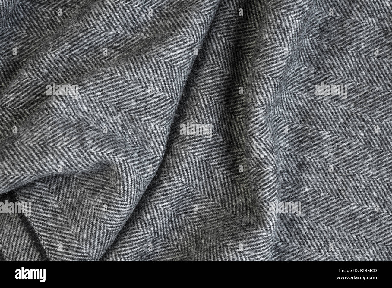 Draped herringbone tweed background with closeup on wool fabric texture ...