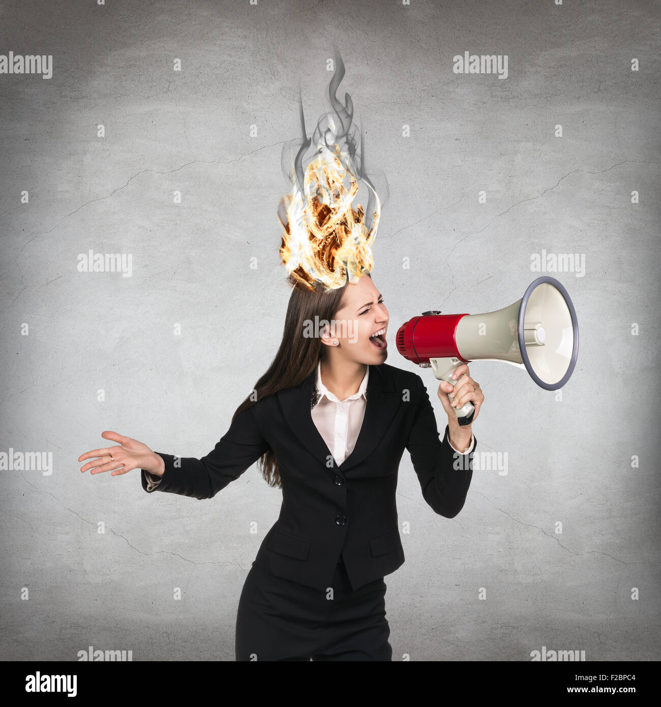 Woman having her brain on fire because of stress on a gray background ...