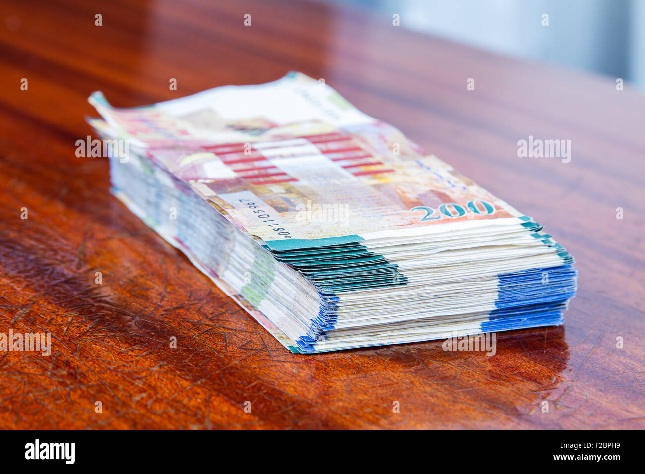 Two hundred and one hundred shekel bank notes against wood background ...