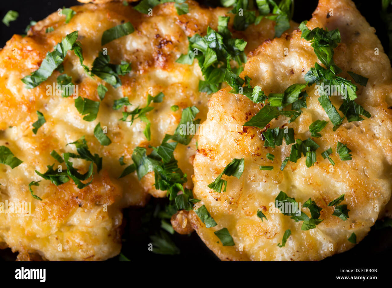 Fried chicken schnitzel with parsley on dark plate Stock Photo - Alamy