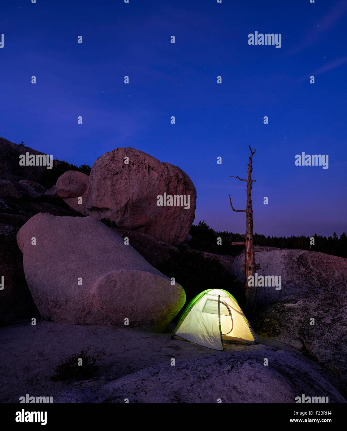 Tent on a camping trip at night on a barren, rocky landscape surrounded ...