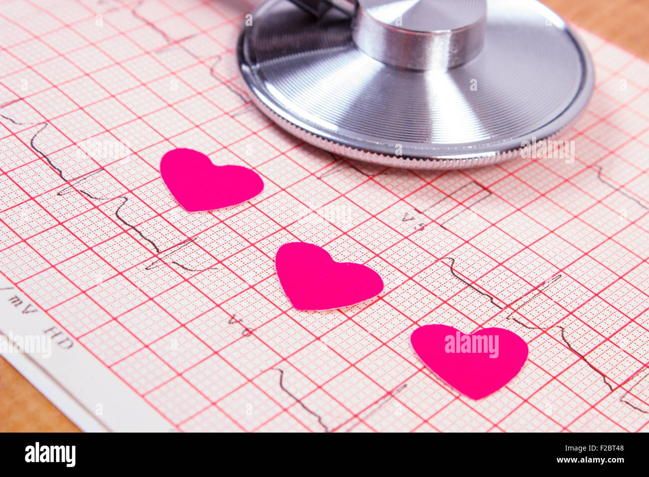 Hearts of paper and medical stethoscope lying on electrocardiogram ...