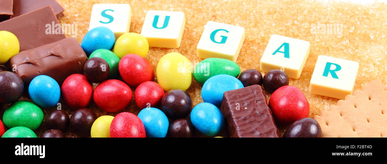 Heap of sweet candies and cookies with brown cane sugar and word sugar ...