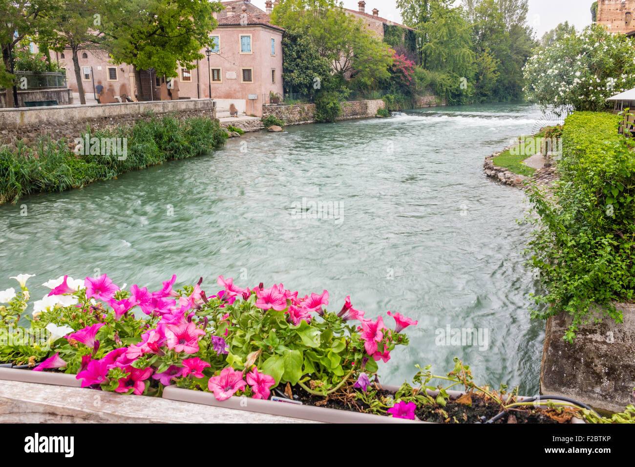ancient buildings of a typical Italian medieval village: the river runs ...