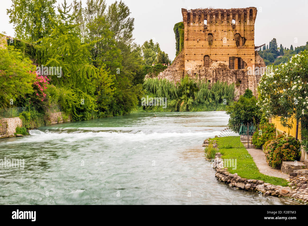 ancient buildings of a typical Italian medieval village: the river runs ...