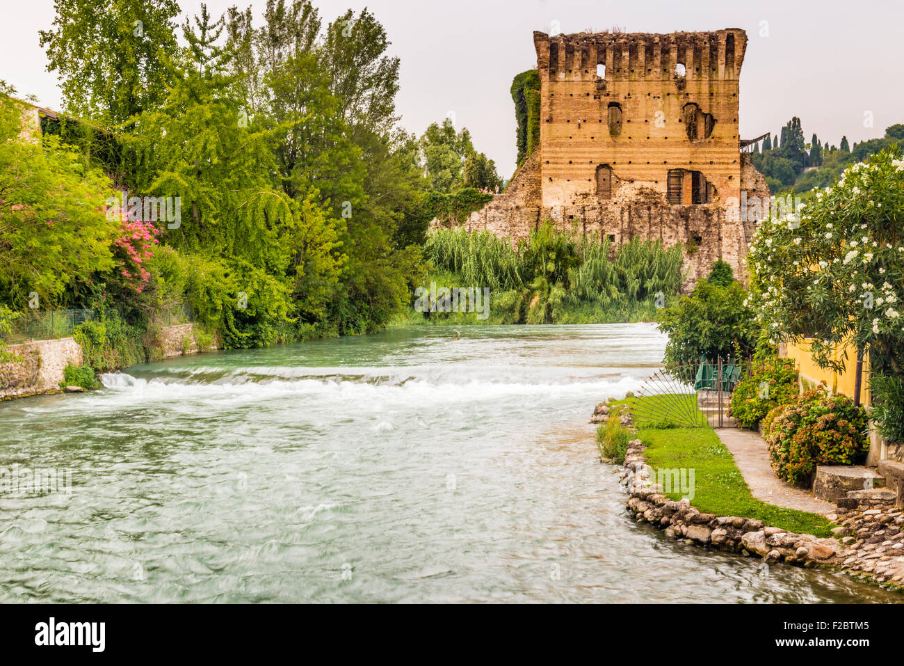 ancient buildings of a typical Italian medieval village: the river runs ...