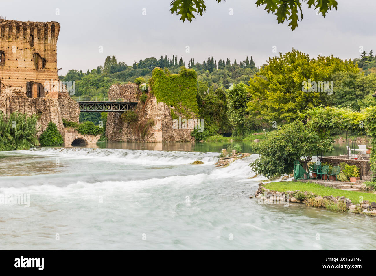 ancient buildings of a typical Italian medieval village: the river runs ...