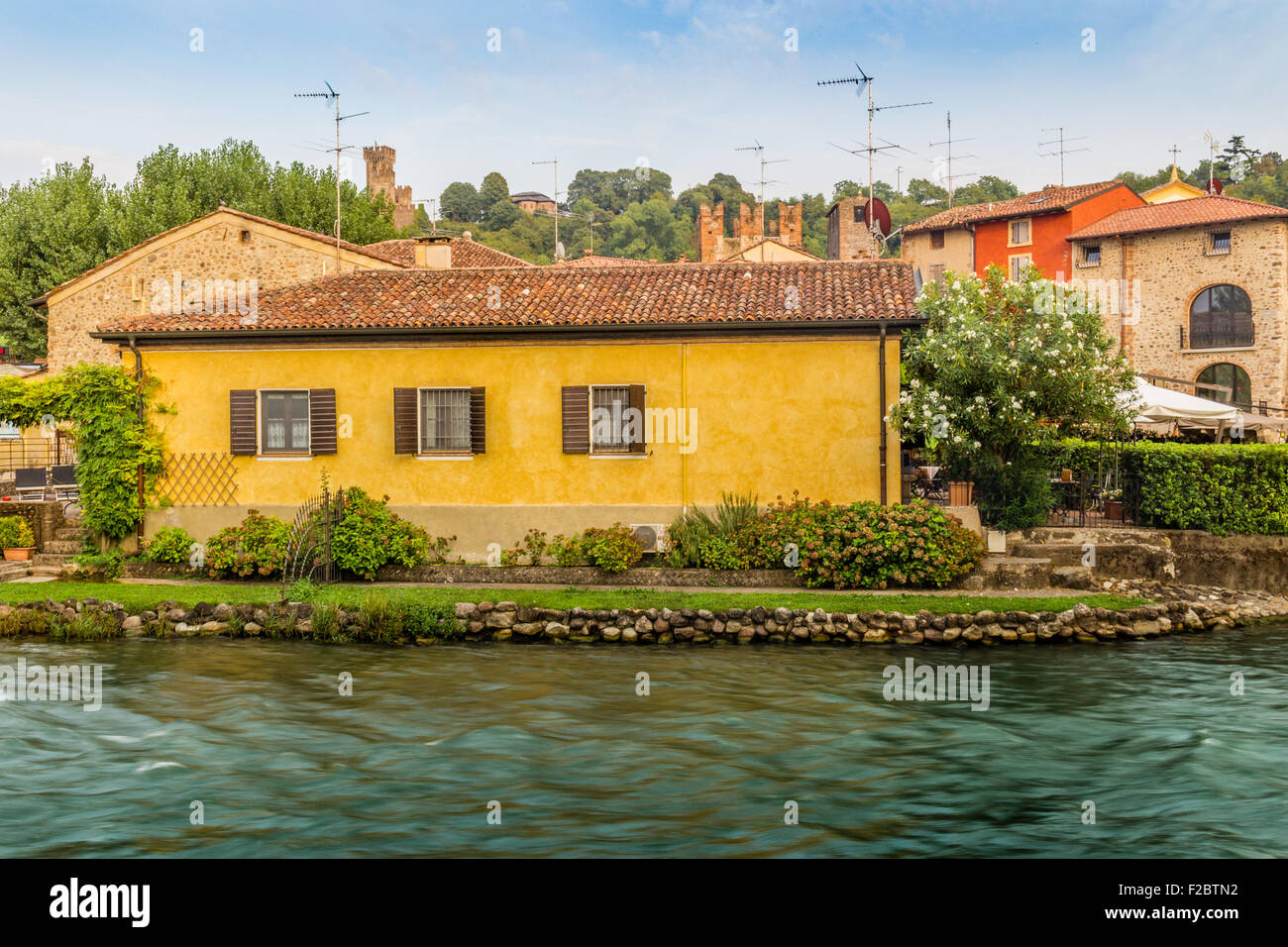 ancient buildings of a typical Italian medieval village: the river runs ...