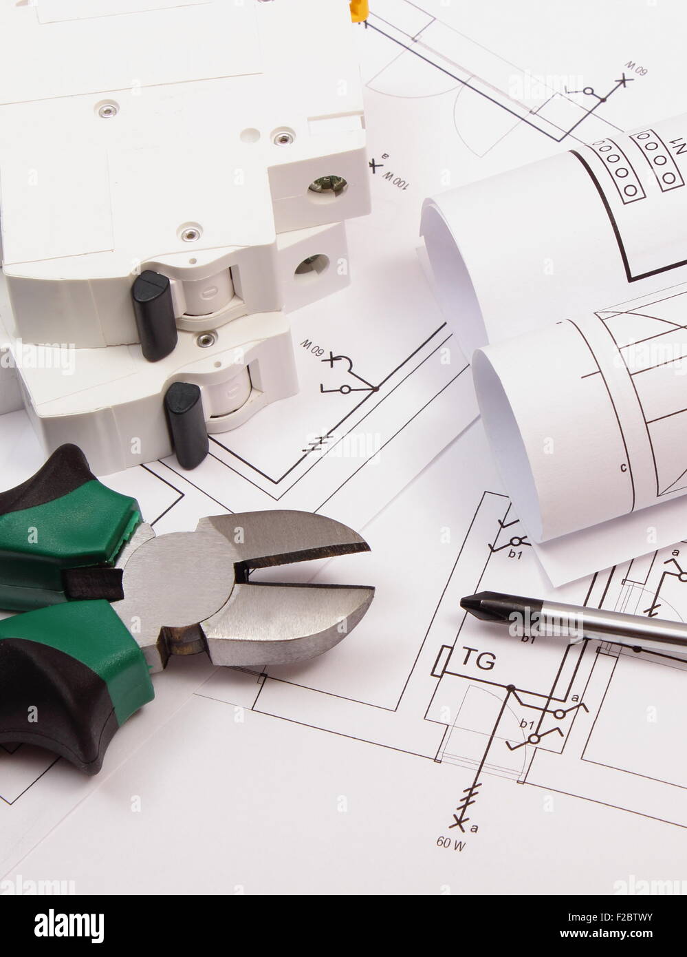 Metal pliers, screwdriver, electric fuse and rolls of diagrams on ...