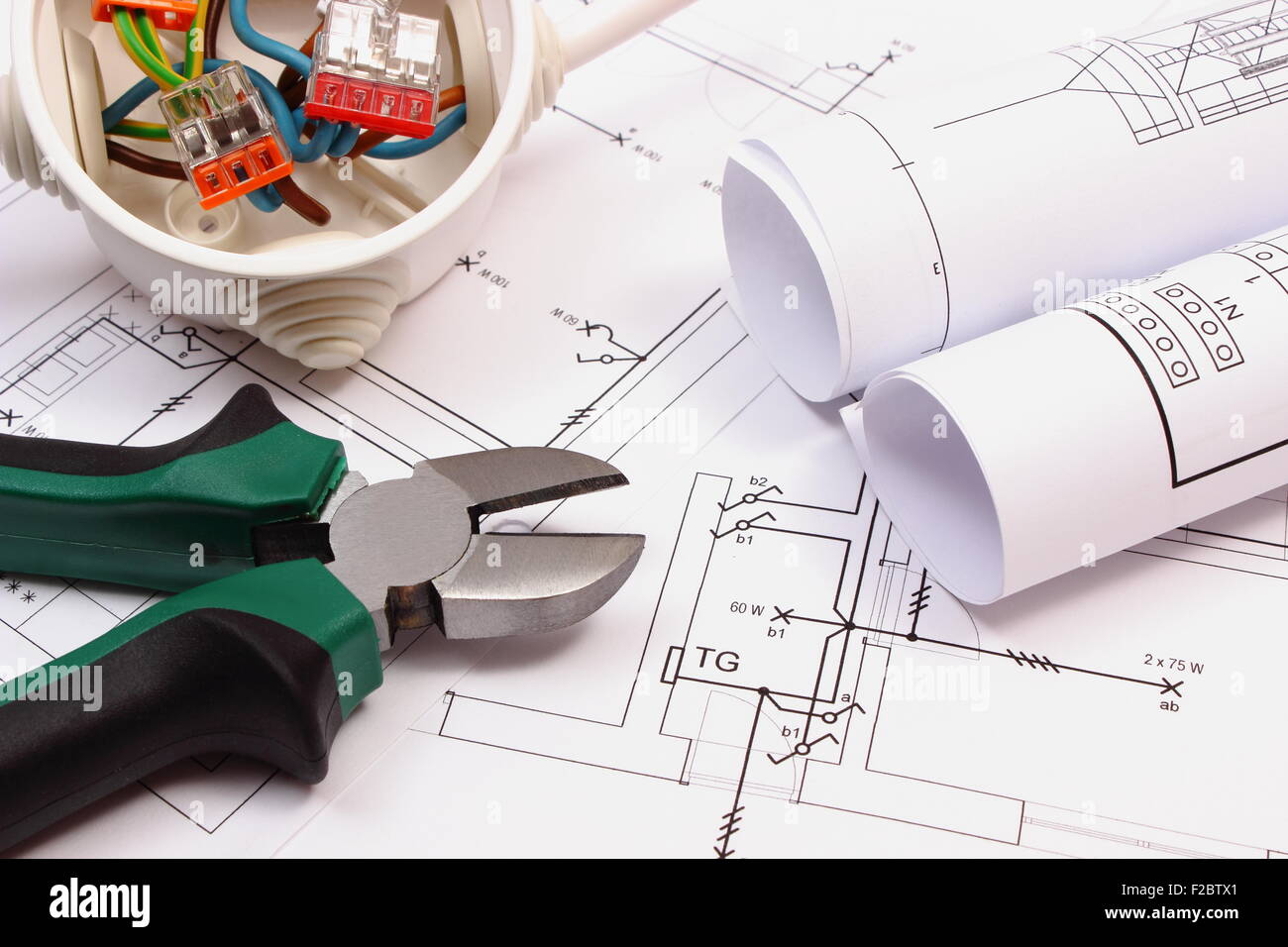 Metal pliers, rolls of diagrams and cable connections in electrical box ...
