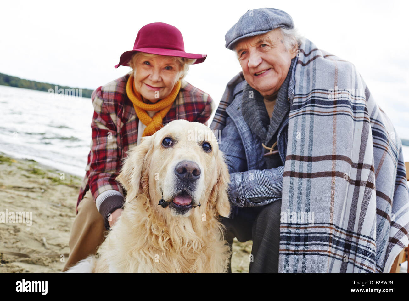 Retired couple and their pet relaxing by seaside on weekend Stock Photo ...