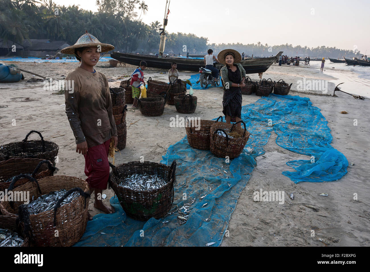 Native people standing around baskets of freshly caught fish on the ...