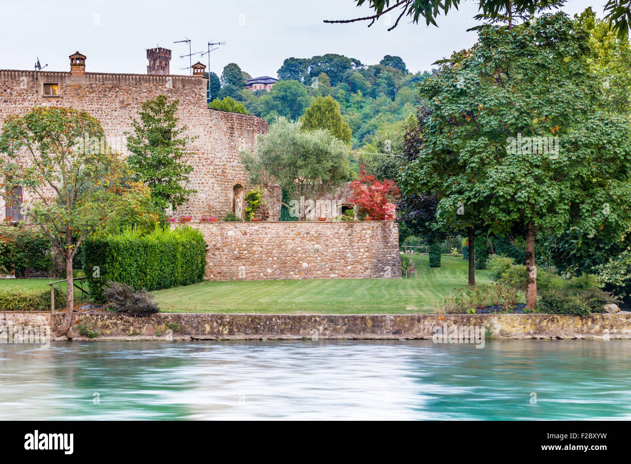 ancient buildings of a typical Italian medieval village: the river runs ...
