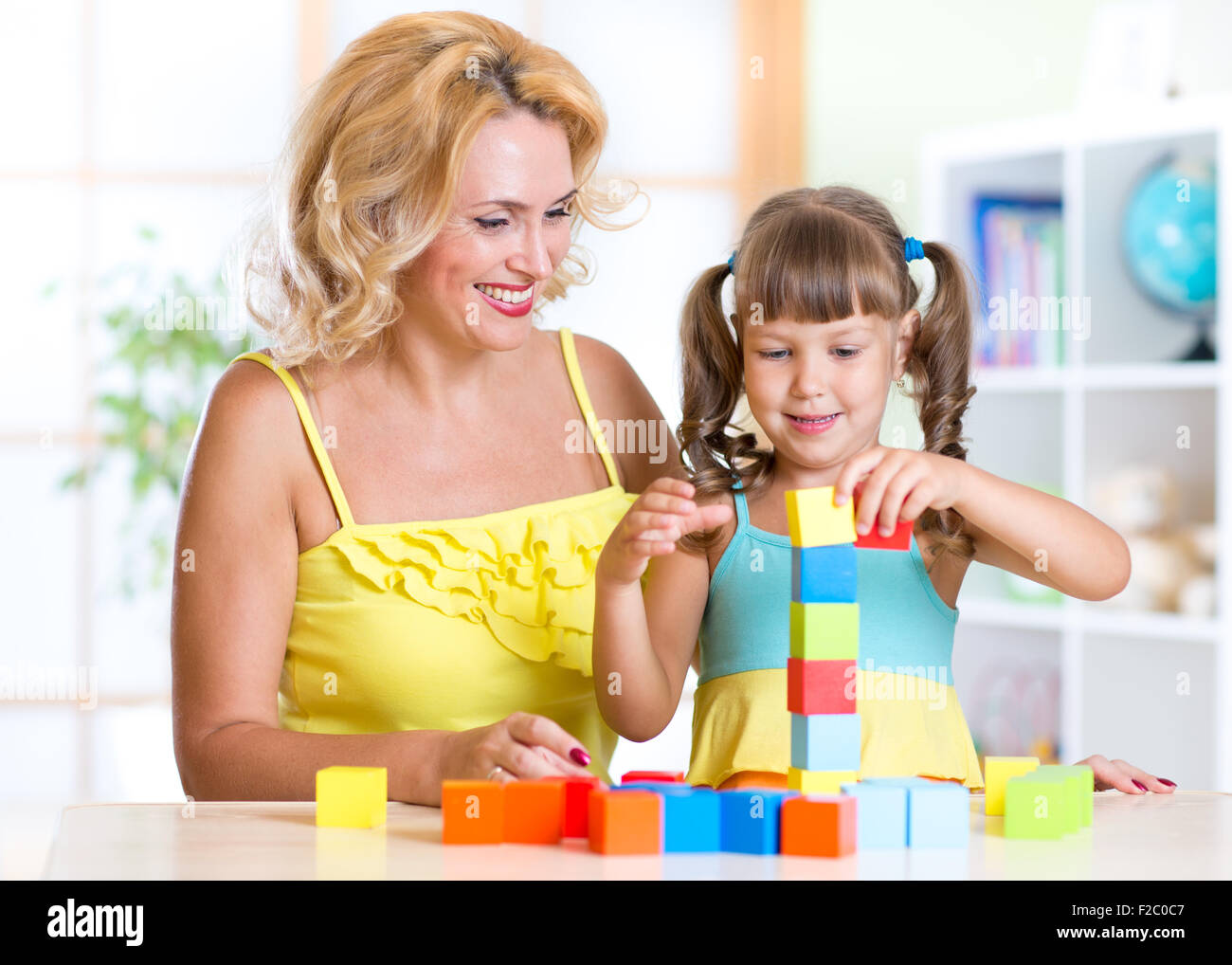 Family mother and daughter playing bricks Stock Photo - Alamy