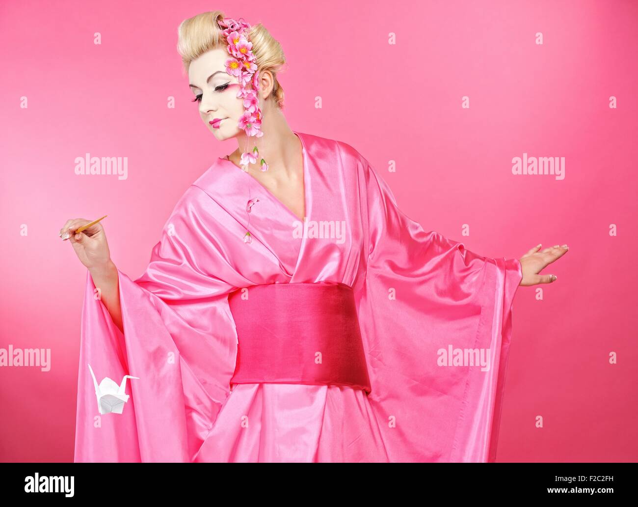 Beautiful geisha holding origami bird Stock Photo - Alamy