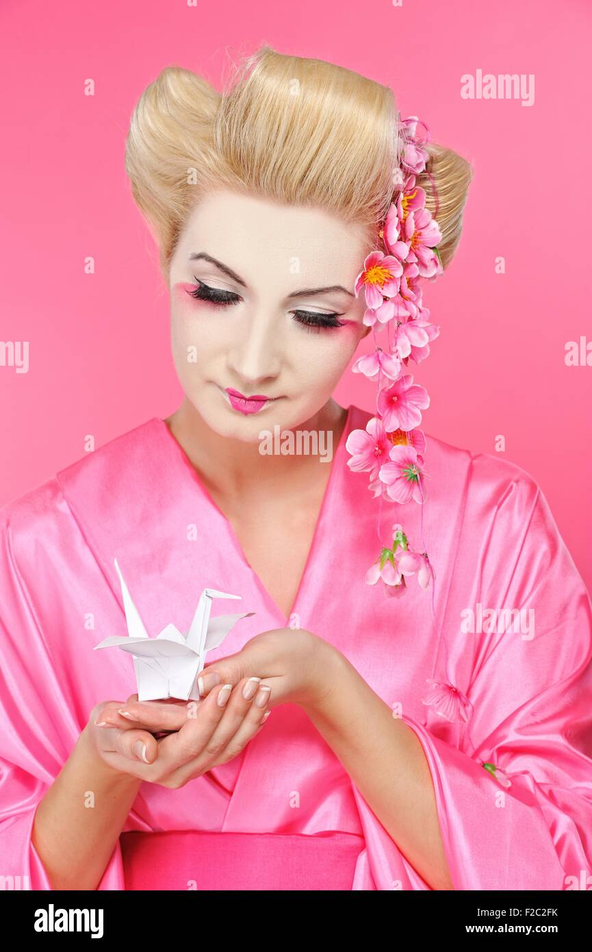 Beautiful geisha holding origami bird Stock Photo - Alamy