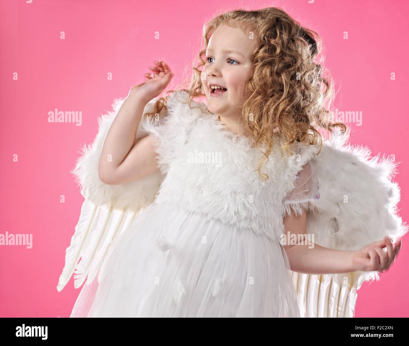 Beautiful little angel girl isolated on pink background Stock Photo - Alamy