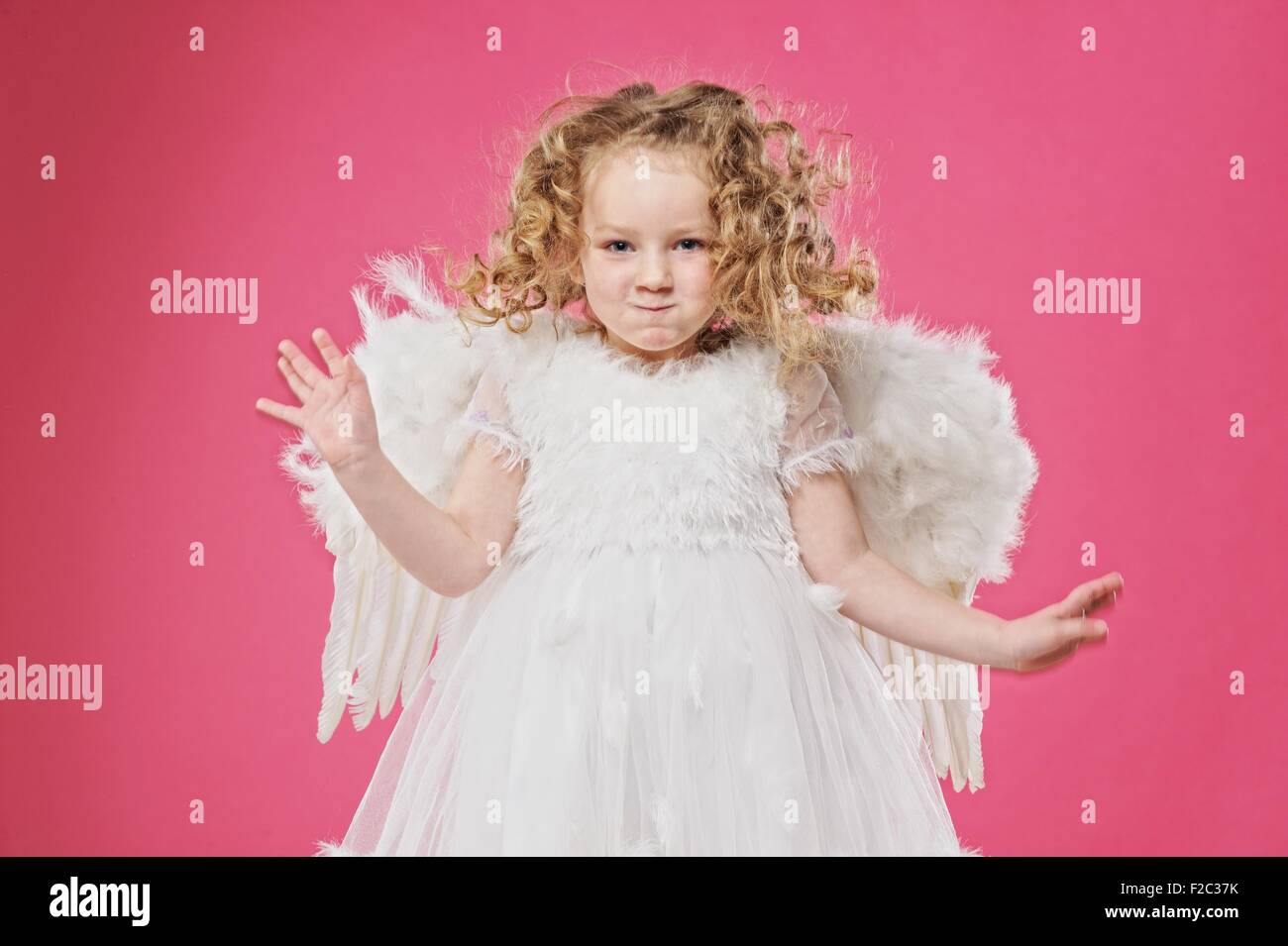 Beautiful little angel girl isolated on pink background Stock Photo - Alamy