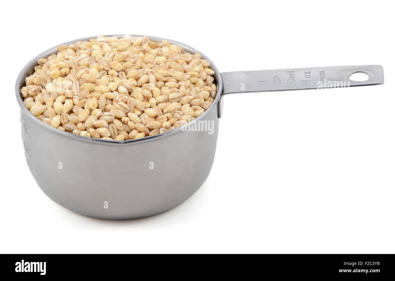 Pearl barley in an American measuring cup, isolated on a white ...