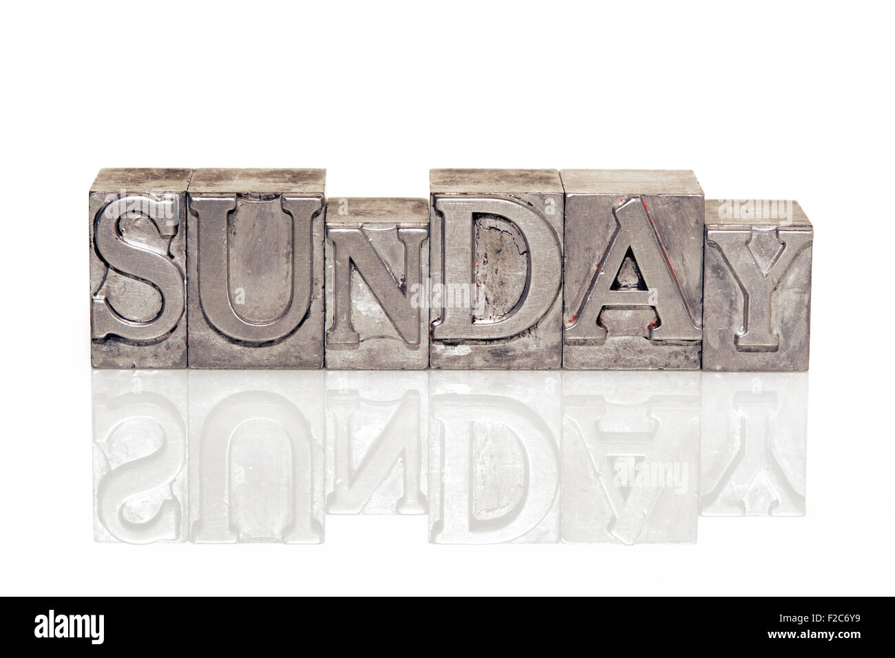 Sunday word made from metallic letterpress type on reflective surface ...