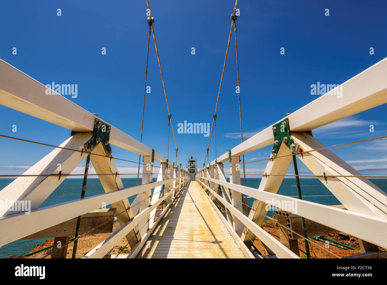 Beautiful suspension bridge to Lighthouse under beautiful sky and ocean ...