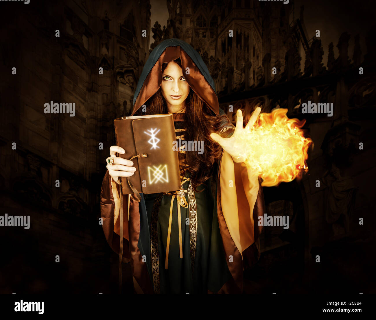 Beautiful young halloween witch wearing vintage gothic dress with hood ...