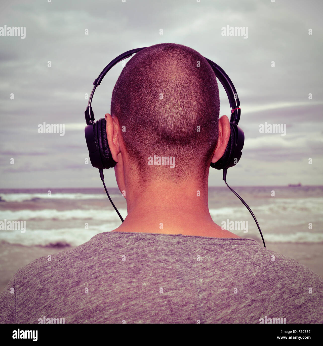 Man listening to headphones from behind hi-res stock photography and ...