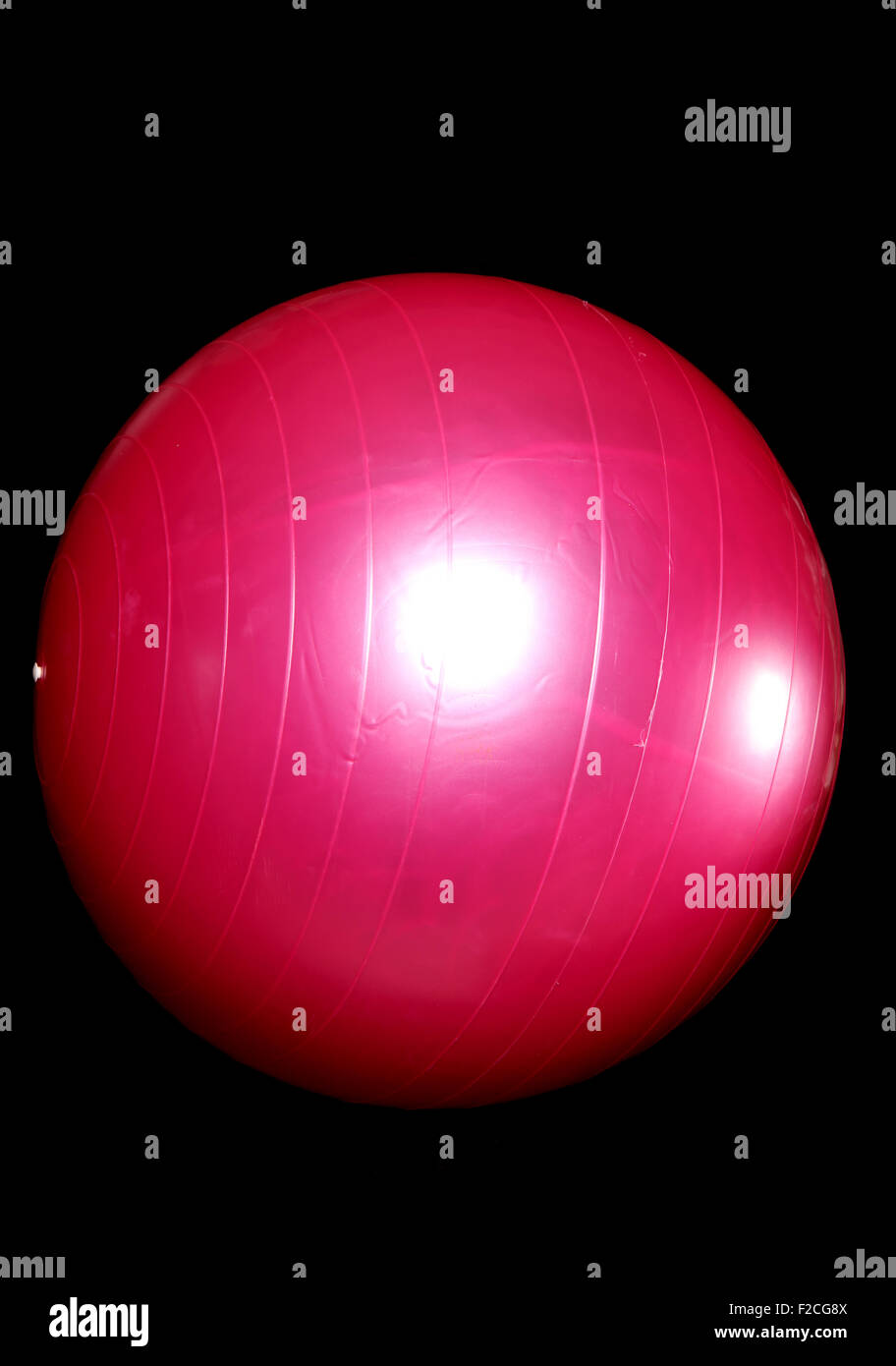 pink exercise ball on black background Stock Photo - Alamy