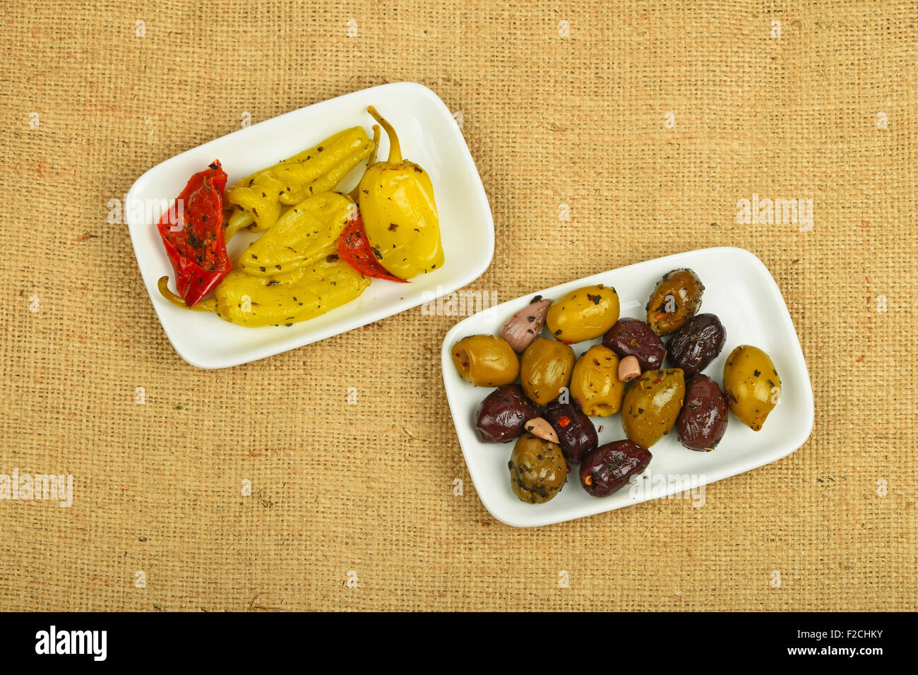 Mediterranean snack of red and green olives and pickled green pepper in ...