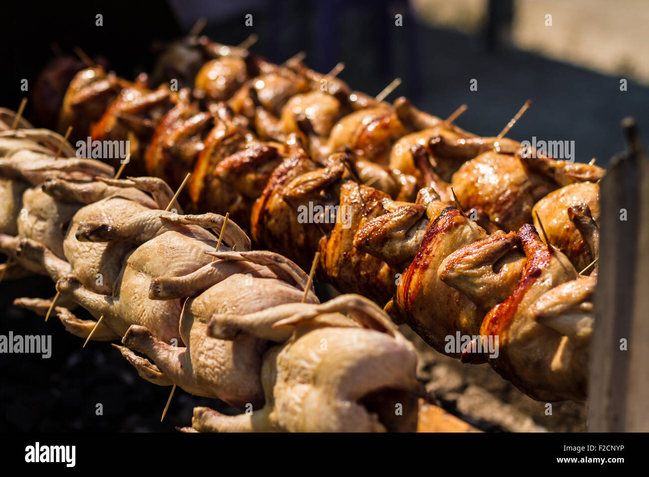 Roast chickens rotating on charcoal grill Stock Photo - Alamy